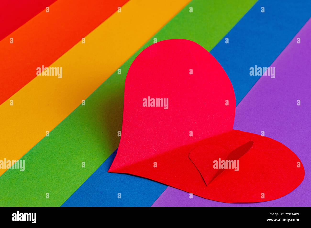 LGBT concept, Two hearts cut out of paper on a rainbow flag Stock Photo ...