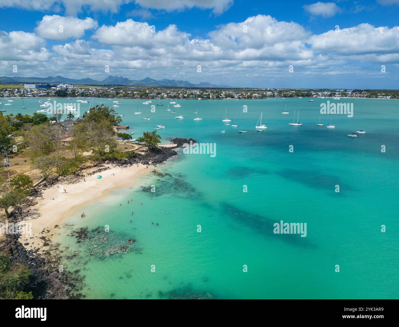 Aerial view of people on beach with sailboats in lagoon, Grand Baie ...