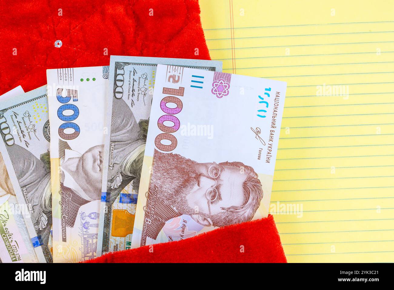 Ukrainian banknotes are visible in bright red pouch placed next to ...