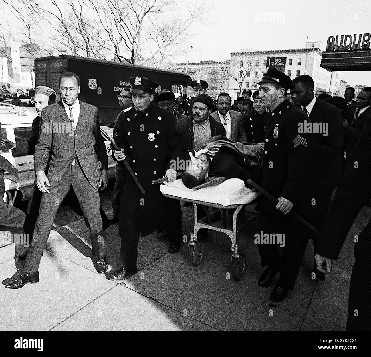 Malcolm X is taken away from the Audubon Ballroom on a stretcher after ...