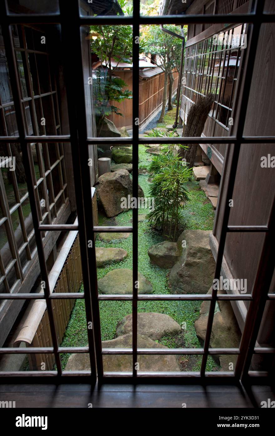 View through sliding glass doors of nakaniwa (small-space courtyard garden) in a residence in ...