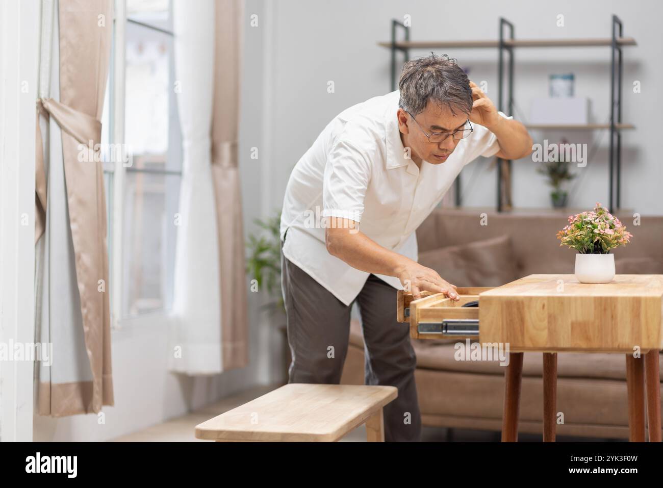 Asian older man finding something that he forgot it in drawers Stock ...