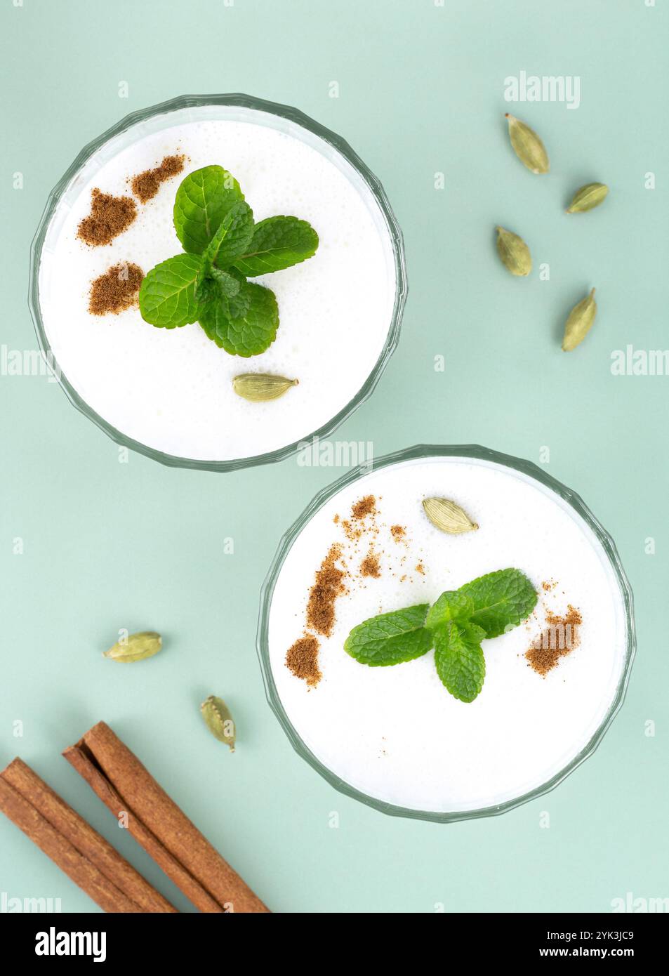 Traditional Indian cold drink lassi in a glass with spices and mint on ...
