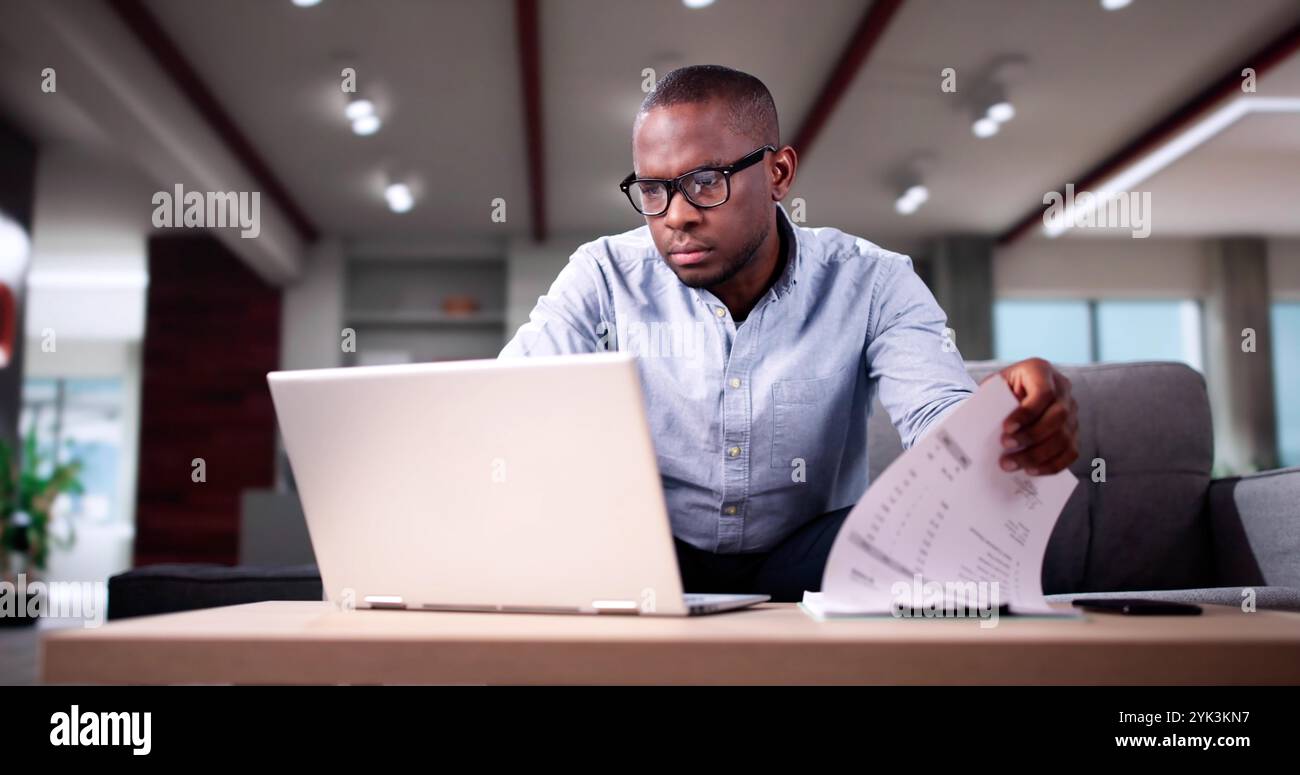 Young African Man Calculating Invoice With Calculator Stock Photo - Alamy