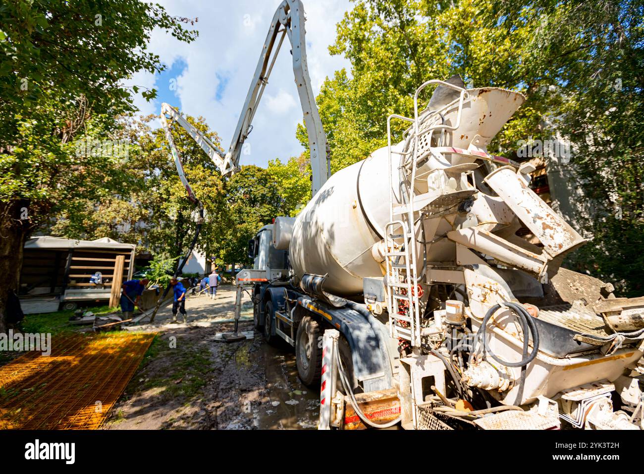 Pouring fresh concrete from mixer truck over ramp to another that has a ...