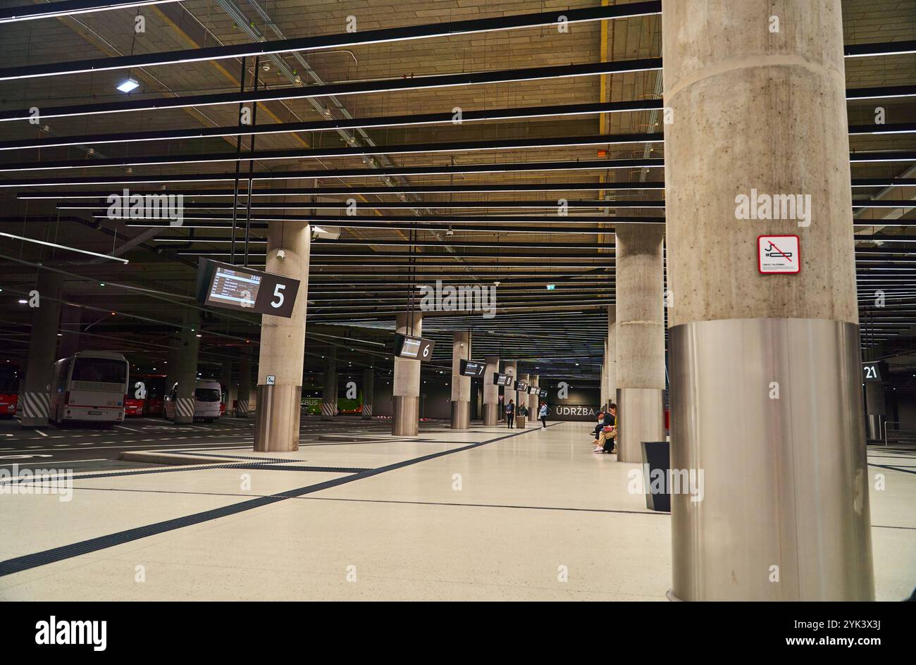 An empty bus station inside with parked buses and large columns Stock ...