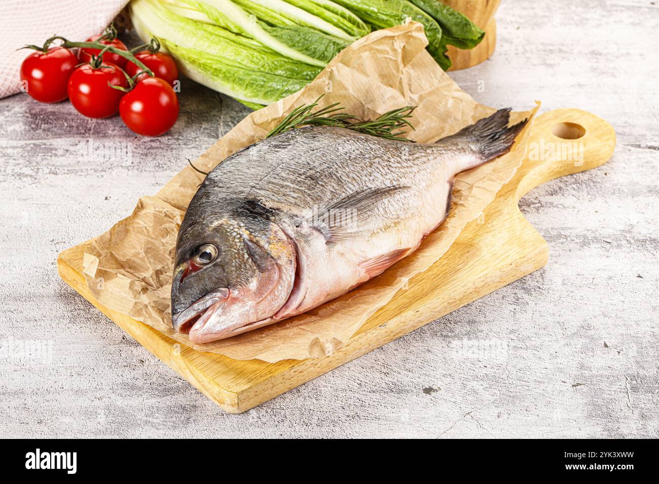 Raw dorada fish served rosemary for cooking Stock Photo - Alamy