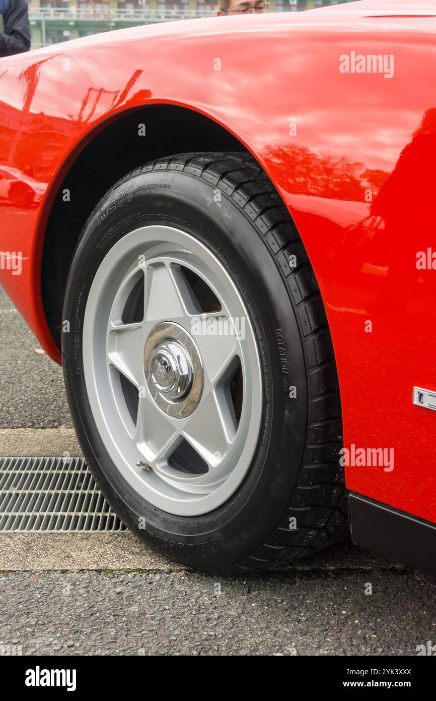 Close up detail of a magnesium knockoff alloy wheel on a rosso corsa ...