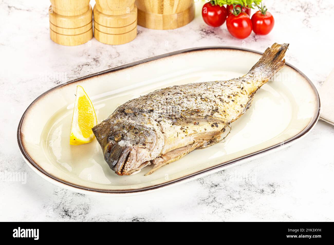 Baked Dorado fish served lemon slice Stock Photo - Alamy