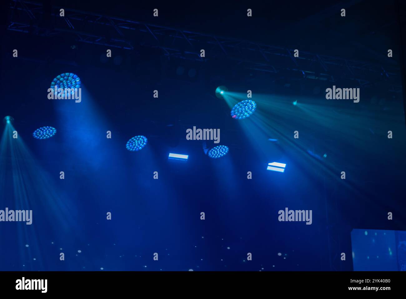 Blue lights casting beams on stage creating mysterious atmosphere ...