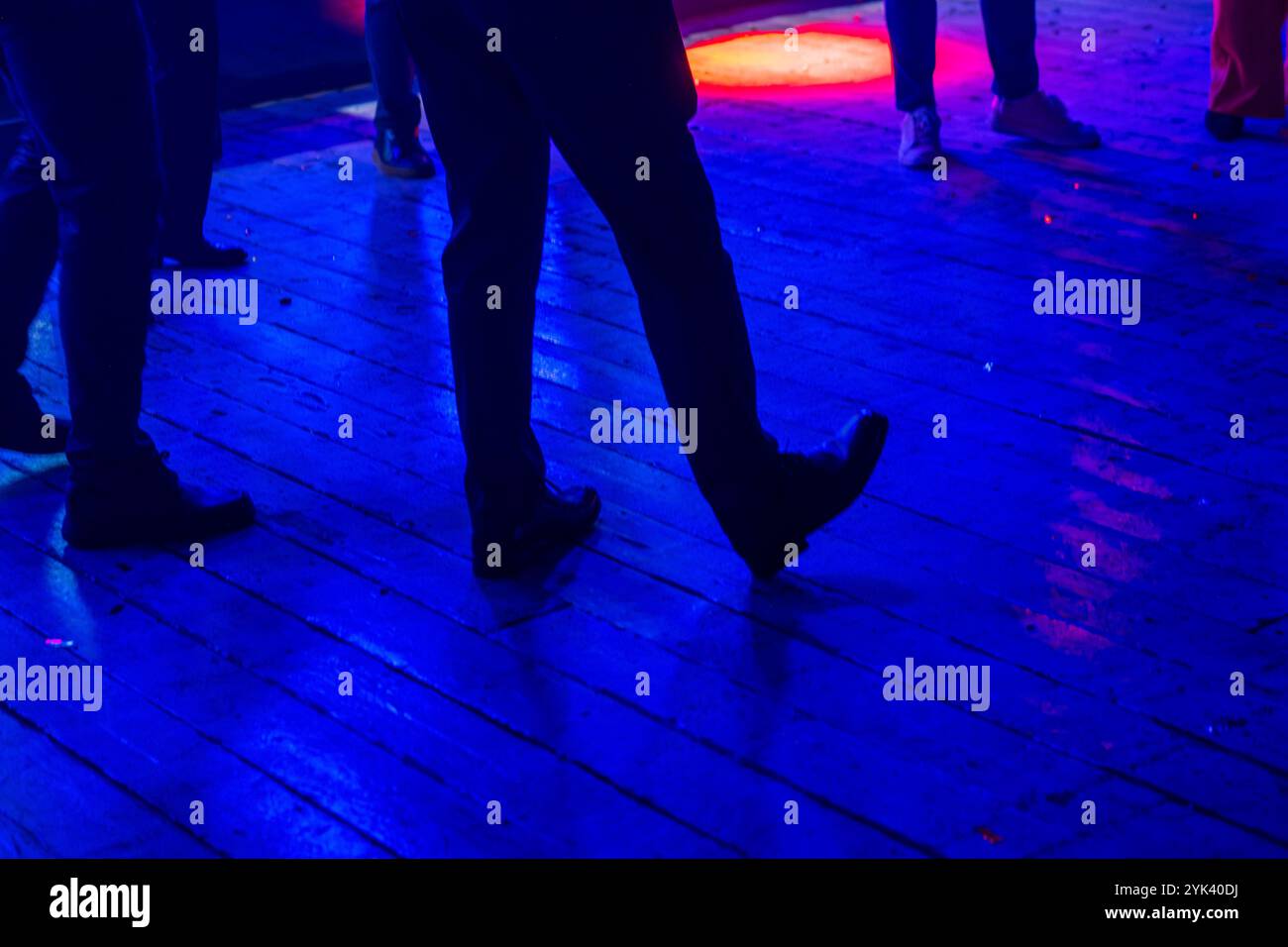 Dynamic scene with colorful lighting highlights feet moving on ...