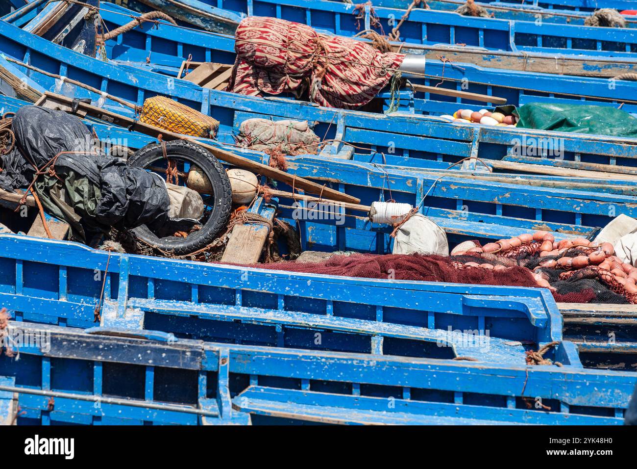 Artisanal fishing boats, made of blue painted wood, in the fishing port ...