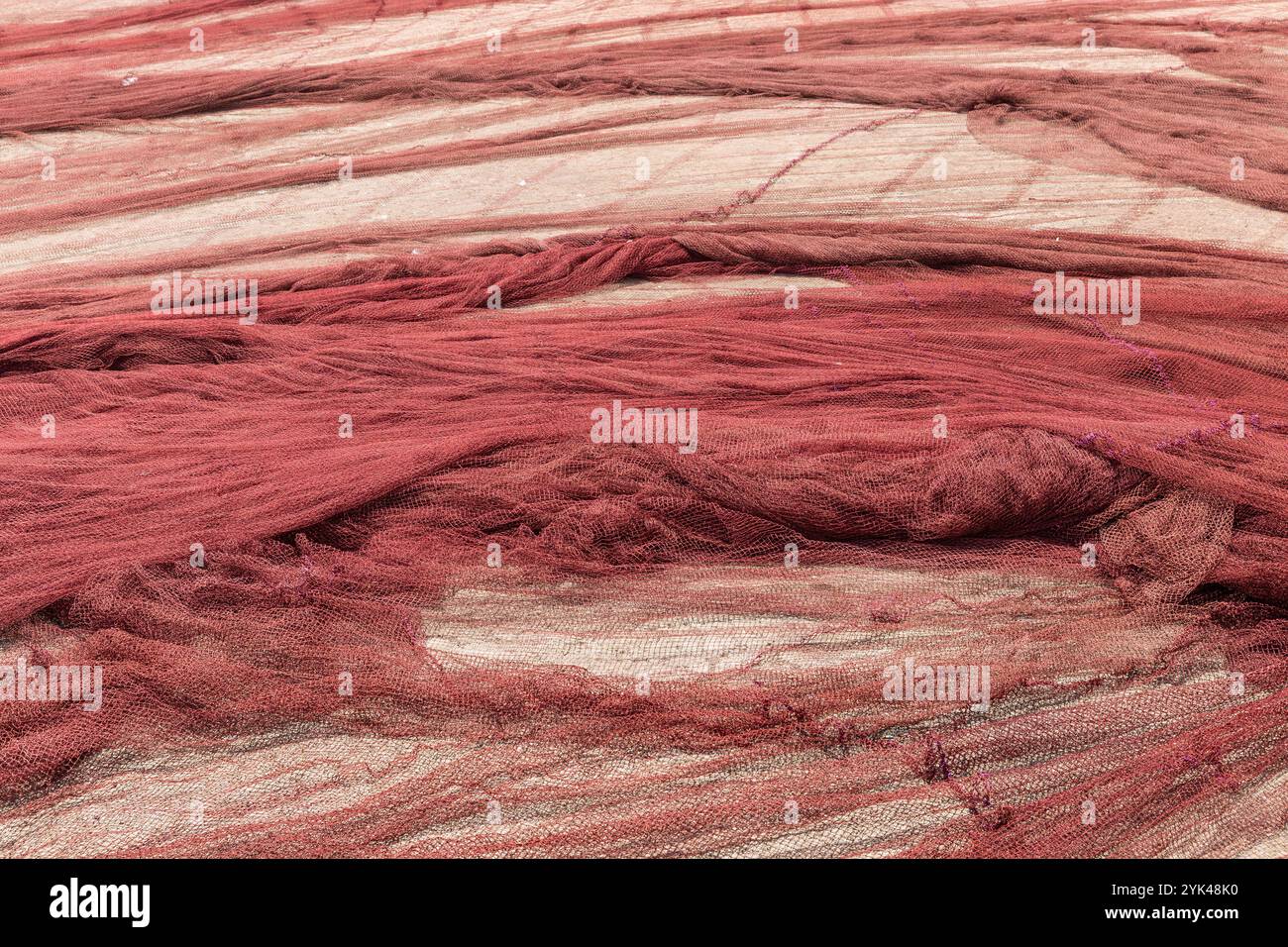 Fishing nets laid out to dry on a quayside in the fishing port of ...