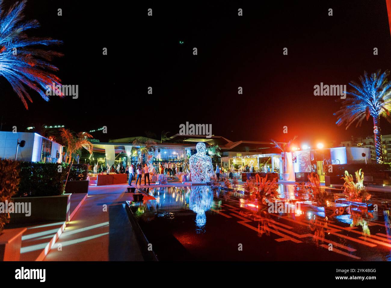 Colorful illumination of the pool terrace at night with vacationing ...