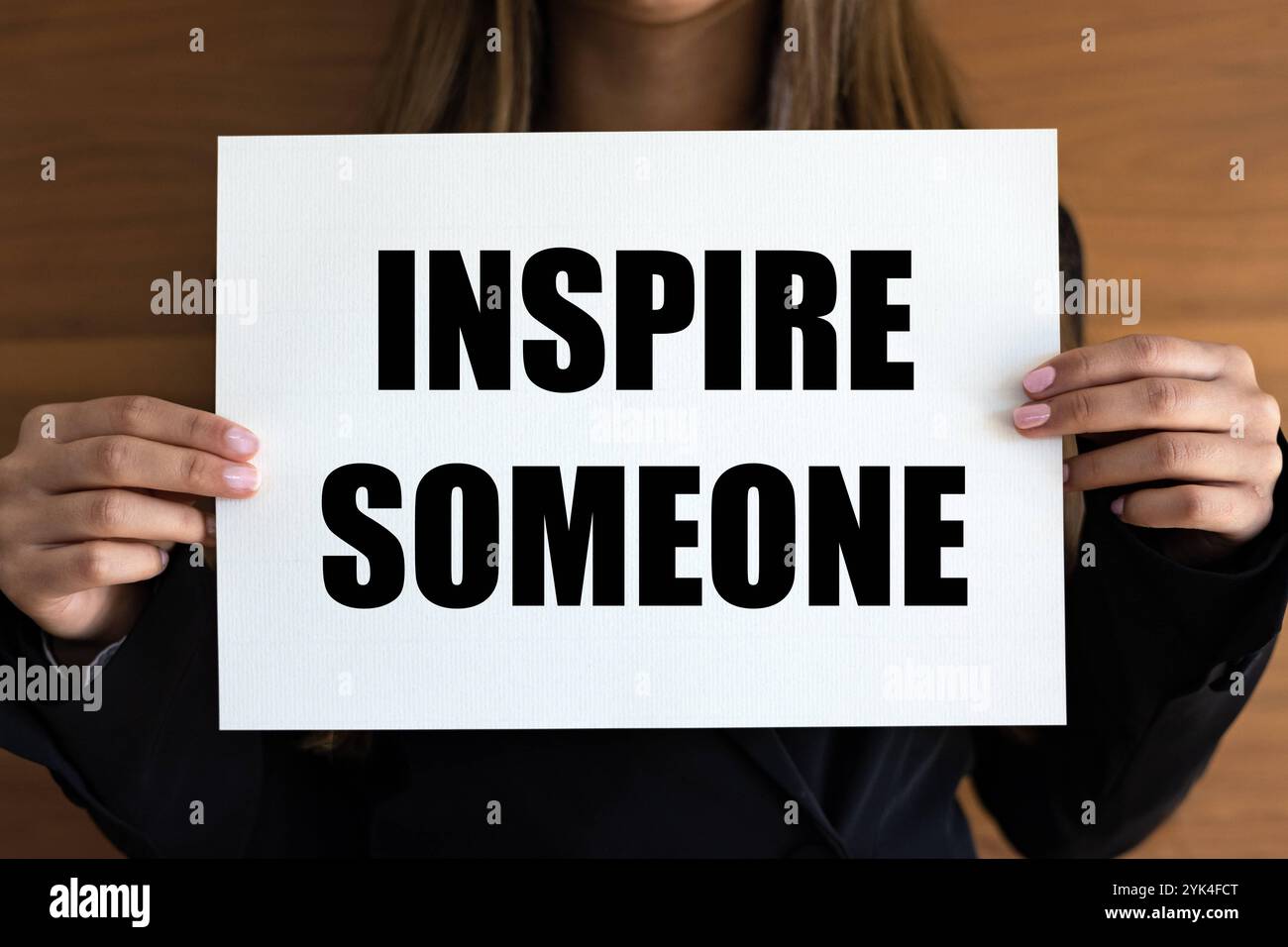Inspire someone. Inspire someone. Woman with white page, black letters ...
