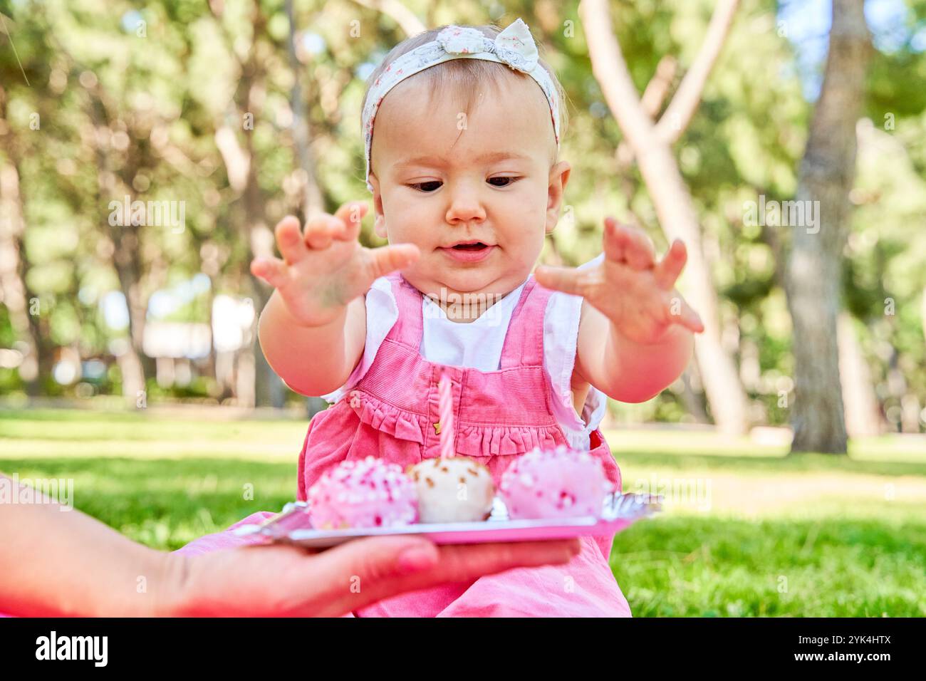 Baby girl in a pink dress clapping with excitement while celebrating ...