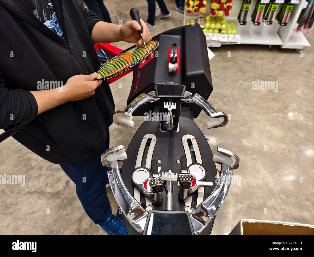 Strings a badminton racket on a racket stringing machine Stock Photo ...