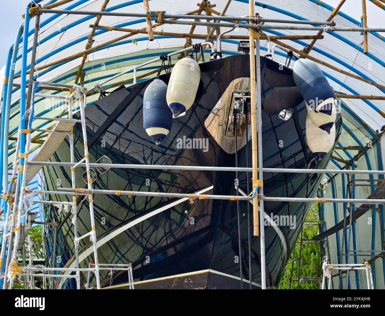 A boat is carefully lifted under a covered structure Stock Photo - Alamy
