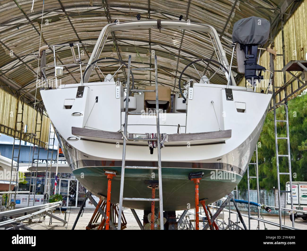 A boat is carefully lifted under a covered structure Stock Photo - Alamy