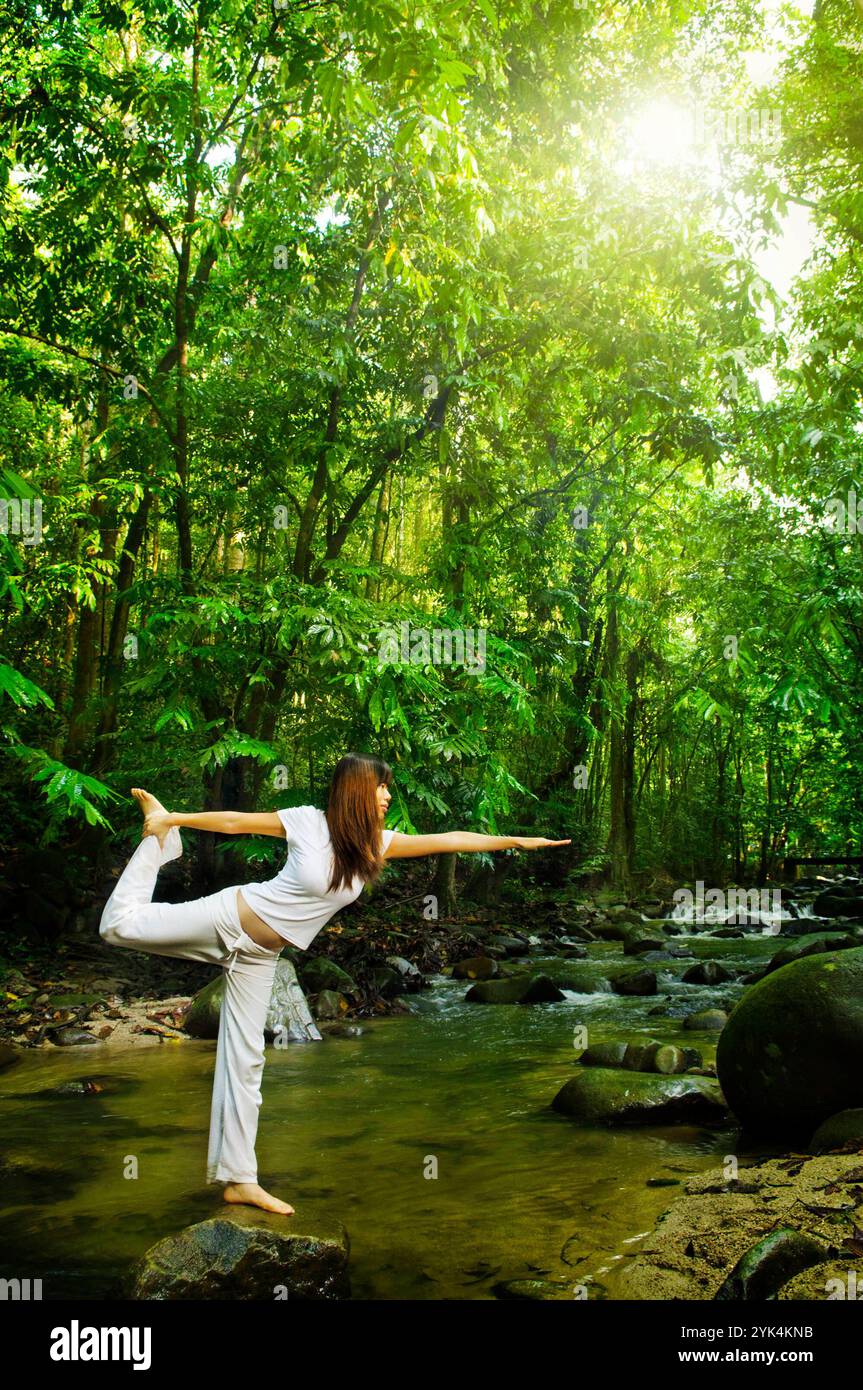 Balancing. Female practises balancing at nature tropical forest in a ...