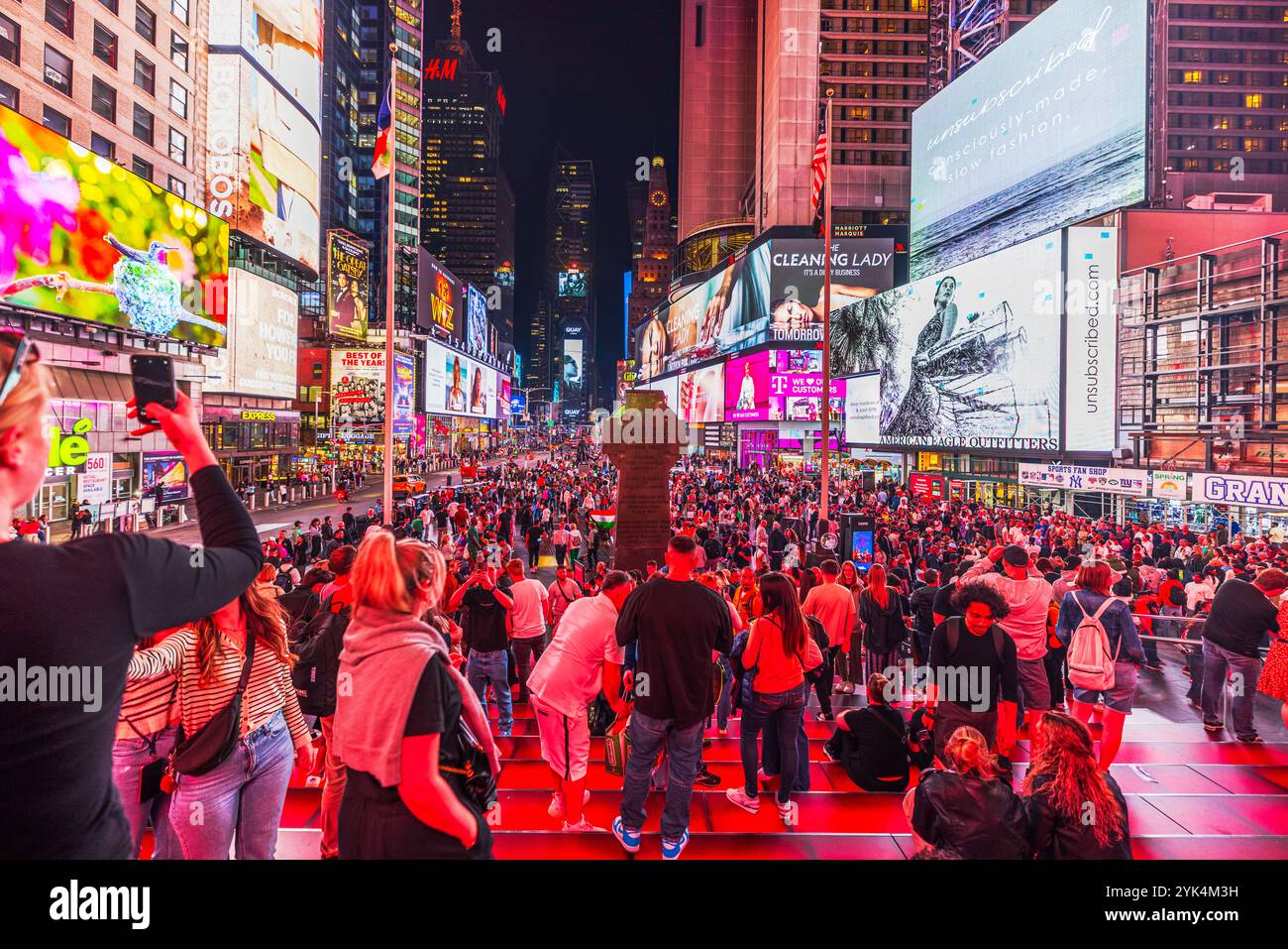 Crowded Times Square at night with illuminated billboards, vibrant ...