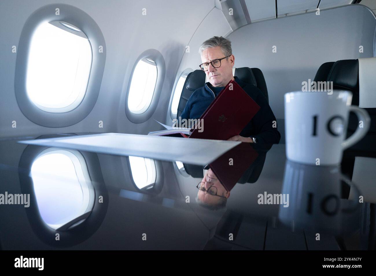 Prime Minister Sir Keir Starmer works on board a Government plane as he ...