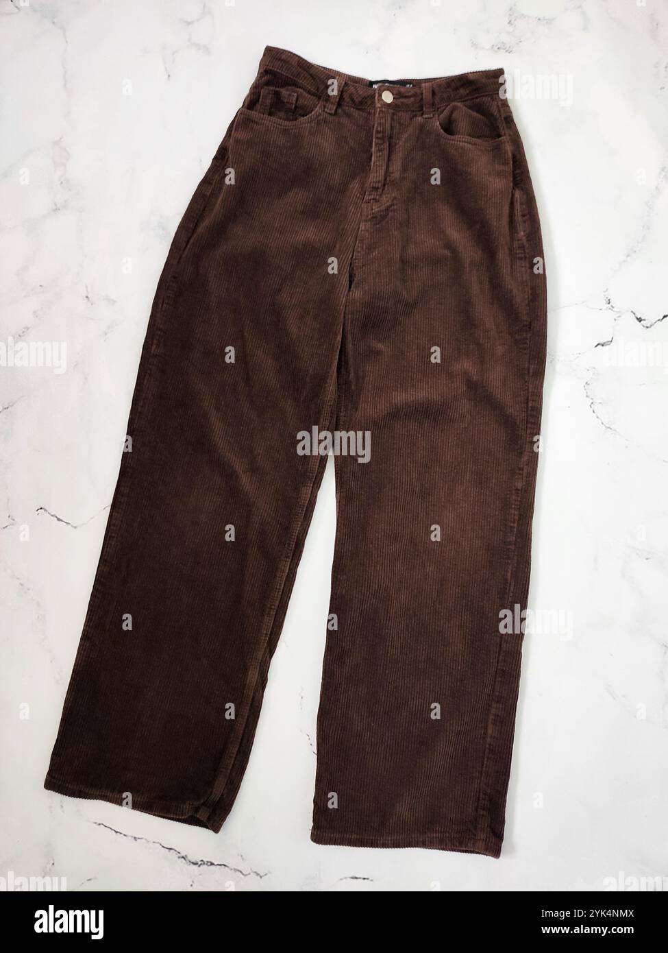 Brown corduroy pants front side flat lay at white marble background top ...