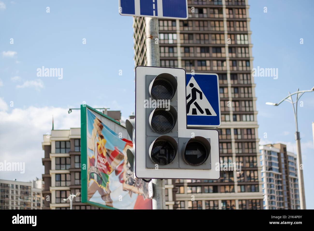A bright red traffic light is hanging down from a tall pole, clearly ...
