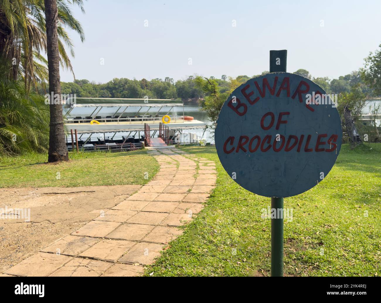 BEWARE OF CROCODILES sign at a lodge garden on Zambezi river banks ...