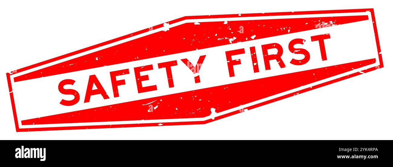 Grunge red safety first word hexagon rubber seal stamp on white ...