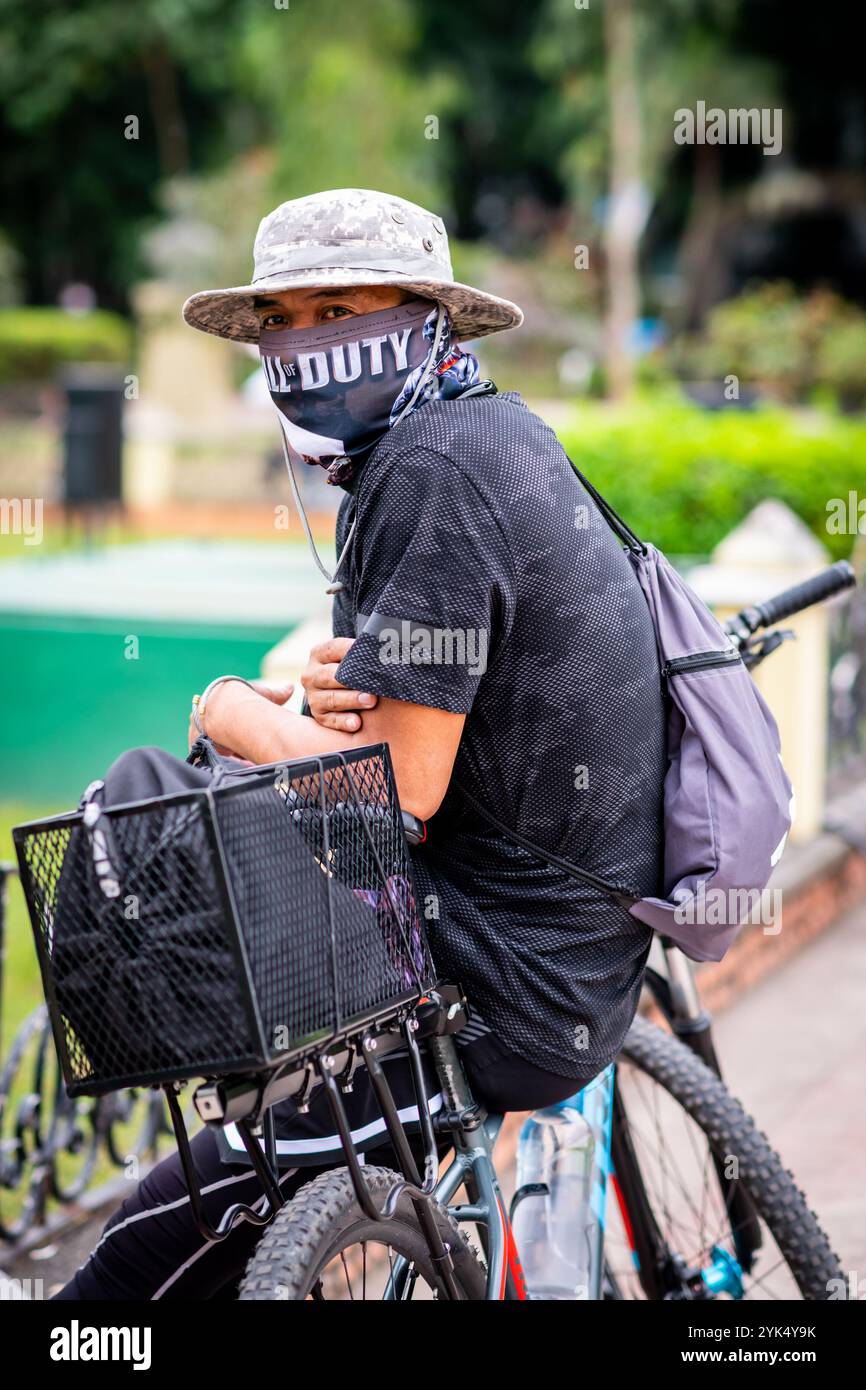 A young Filipina man takes a break from cycling in Rizal Park, Manila ...