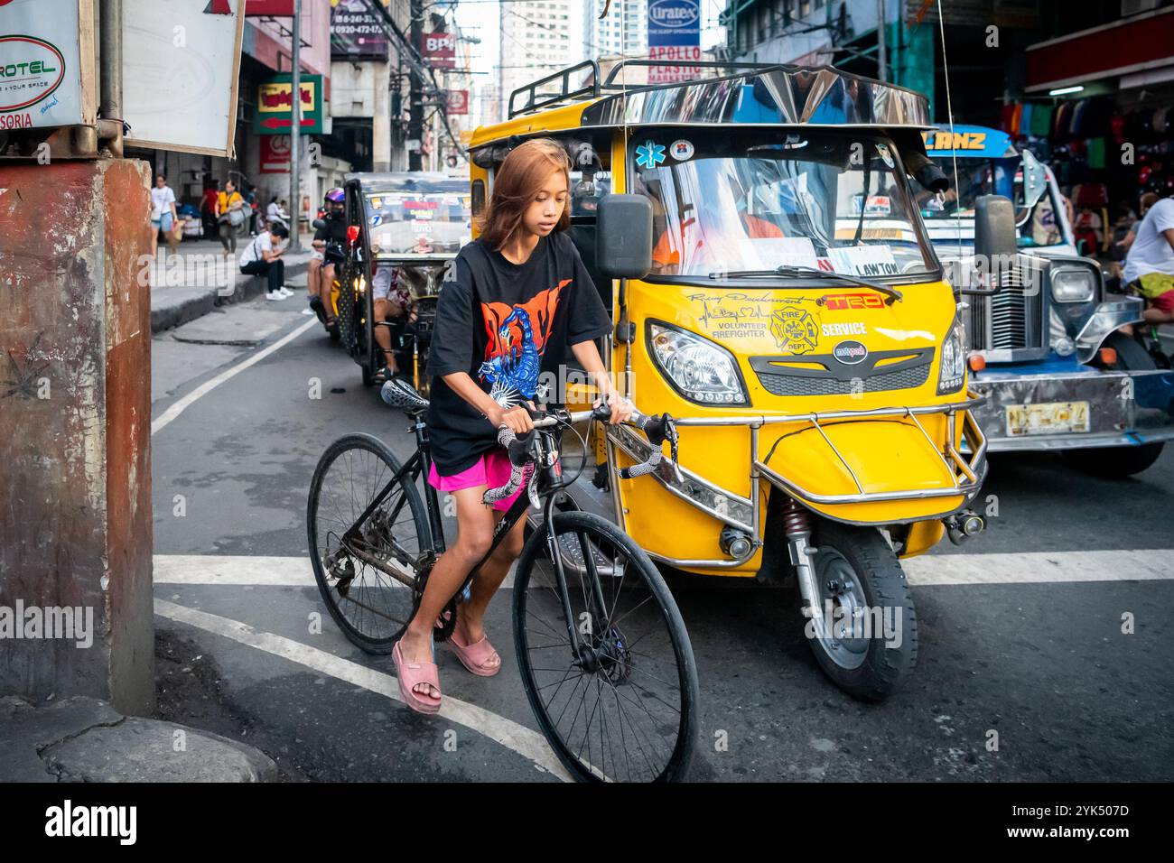 A beautiful young Filipino girl makes her way along a busy market ...
