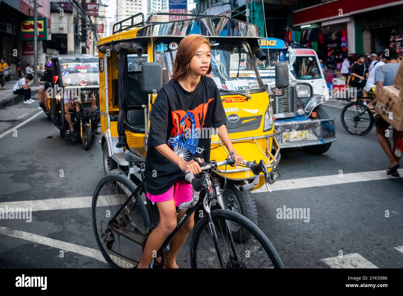 A beautiful young Filipino girl makes her way along a busy market ...
