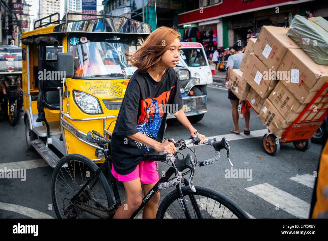 A beautiful young Filipino girl makes her way along a busy market ...