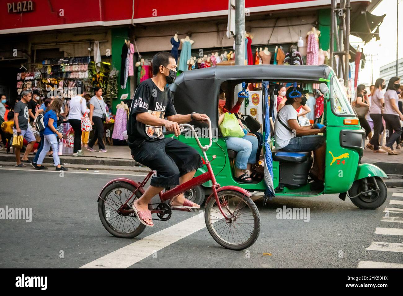 A Filipino man makes his way along a busy market street in the China ...