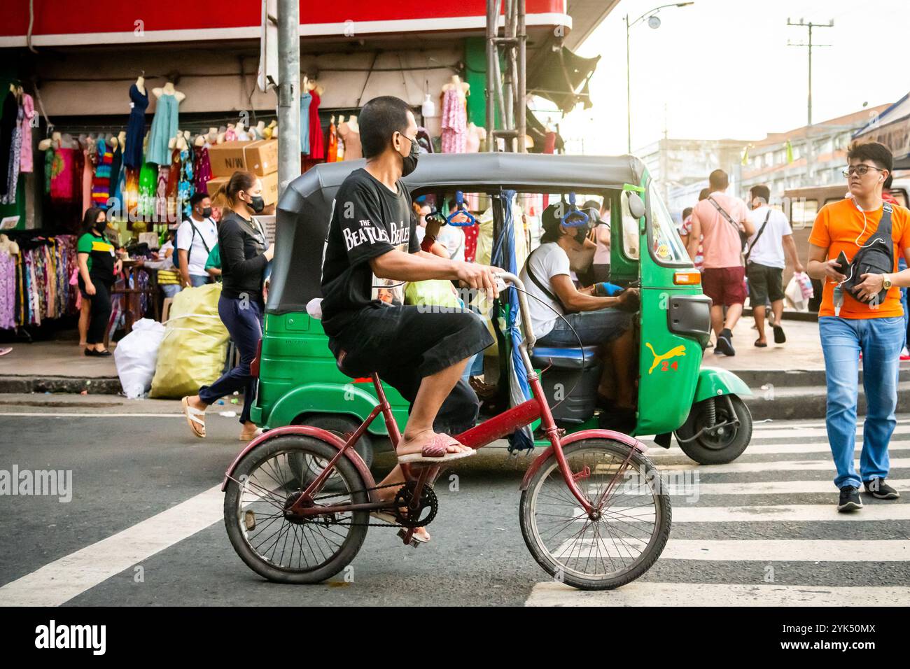 A Filipino man makes his way along a busy market street in the China ...