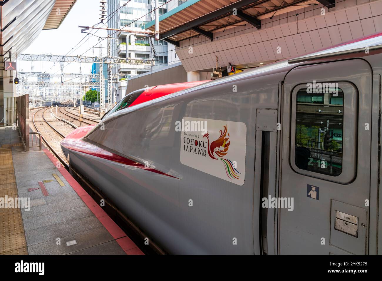 View along the front of a E6 series Tohoku Shinkansen at the platform ...