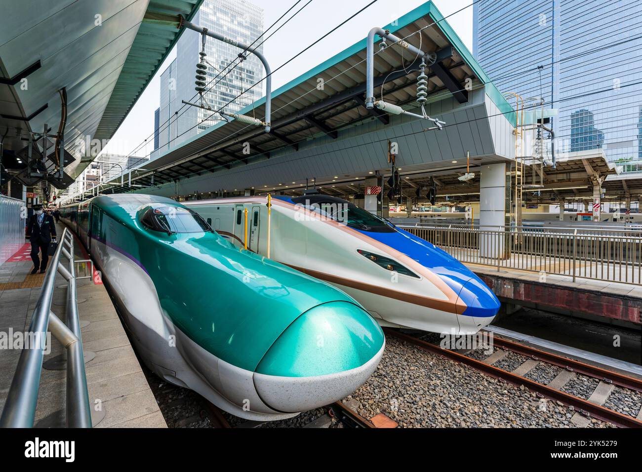 View along two bullet trains waiting at the platofrm in Tokyo. Japanese ...