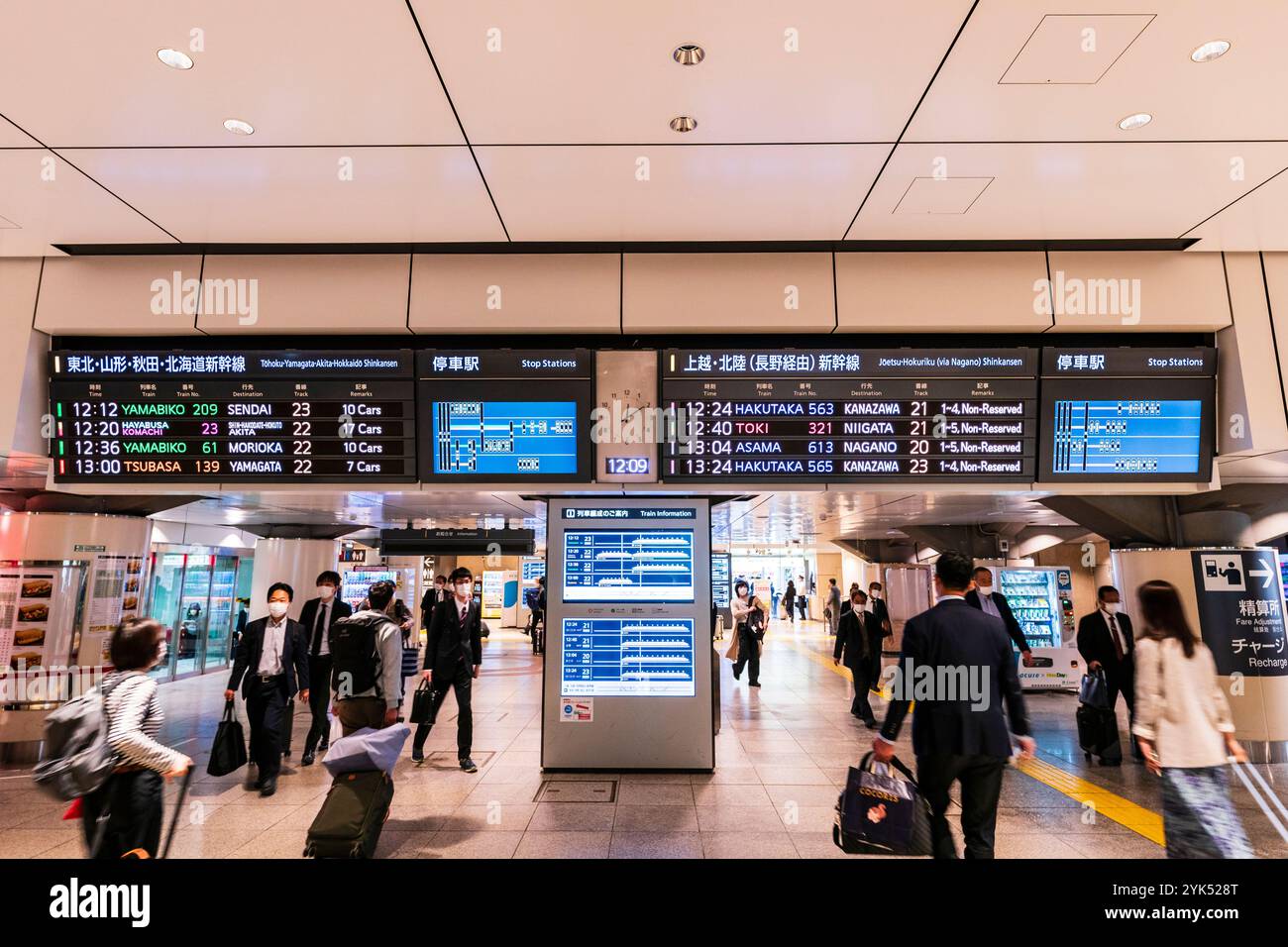 Commuters walking on the concourse with overhead display for various ...