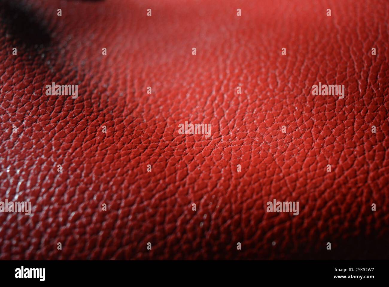 Red, reflective background with fine reliefs made of genuine leather ...