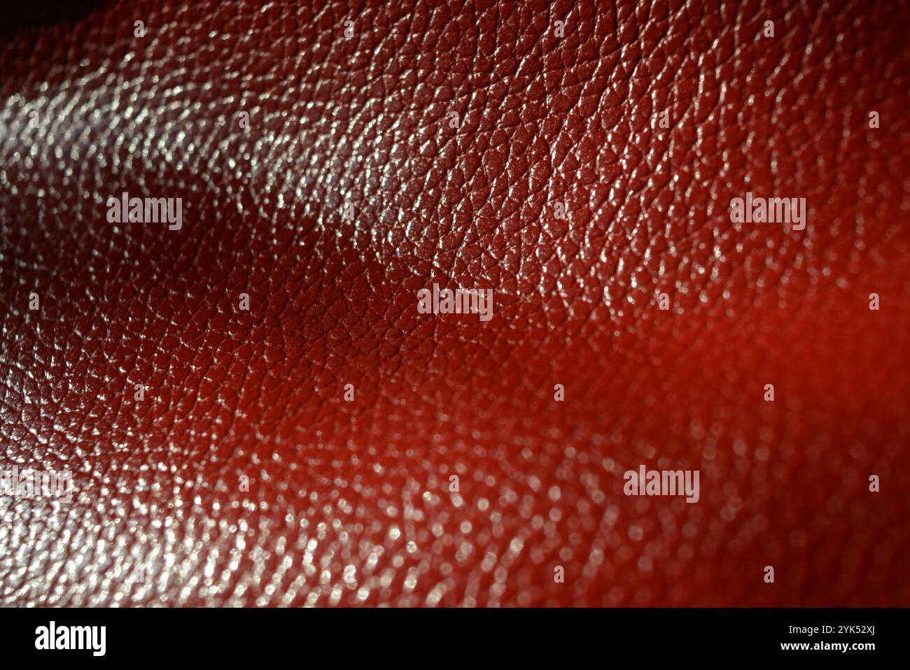 Red, reflective background with fine reliefs made of genuine leather ...