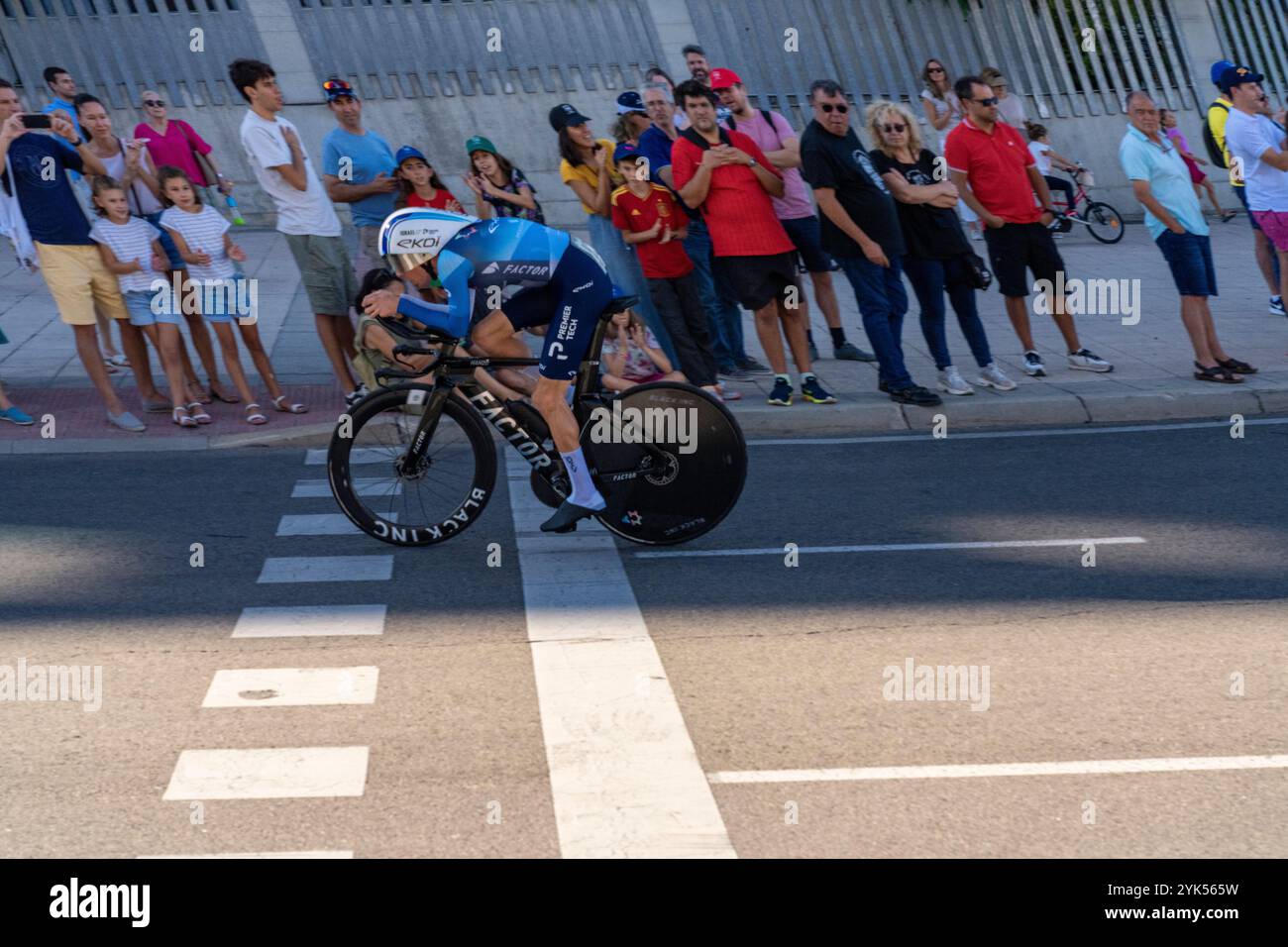 Cyclist in a race crossing the finish line with spectators watching ...