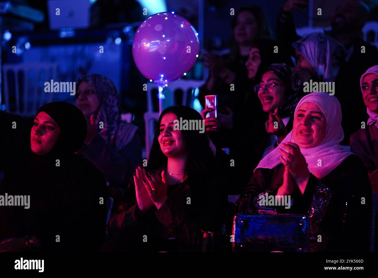 People watch a musical performance during the Baghdad Day Festival on ...