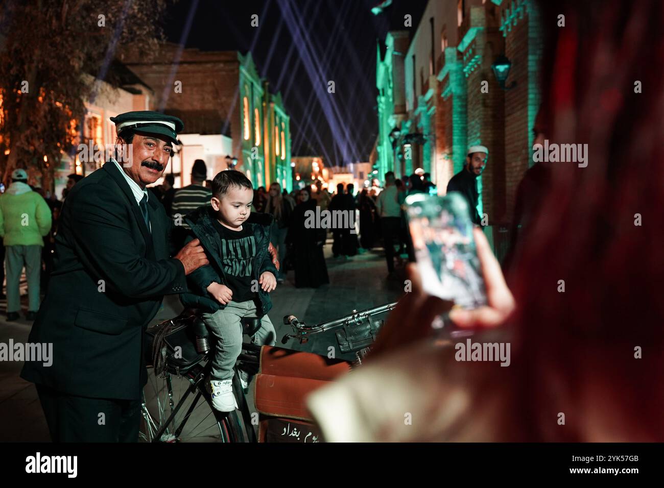 A young woman takes a picture of a child sitting with a man dressed as ...