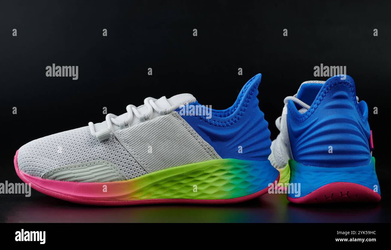 Pair of colorful running shoes side view isolated on black studio ...