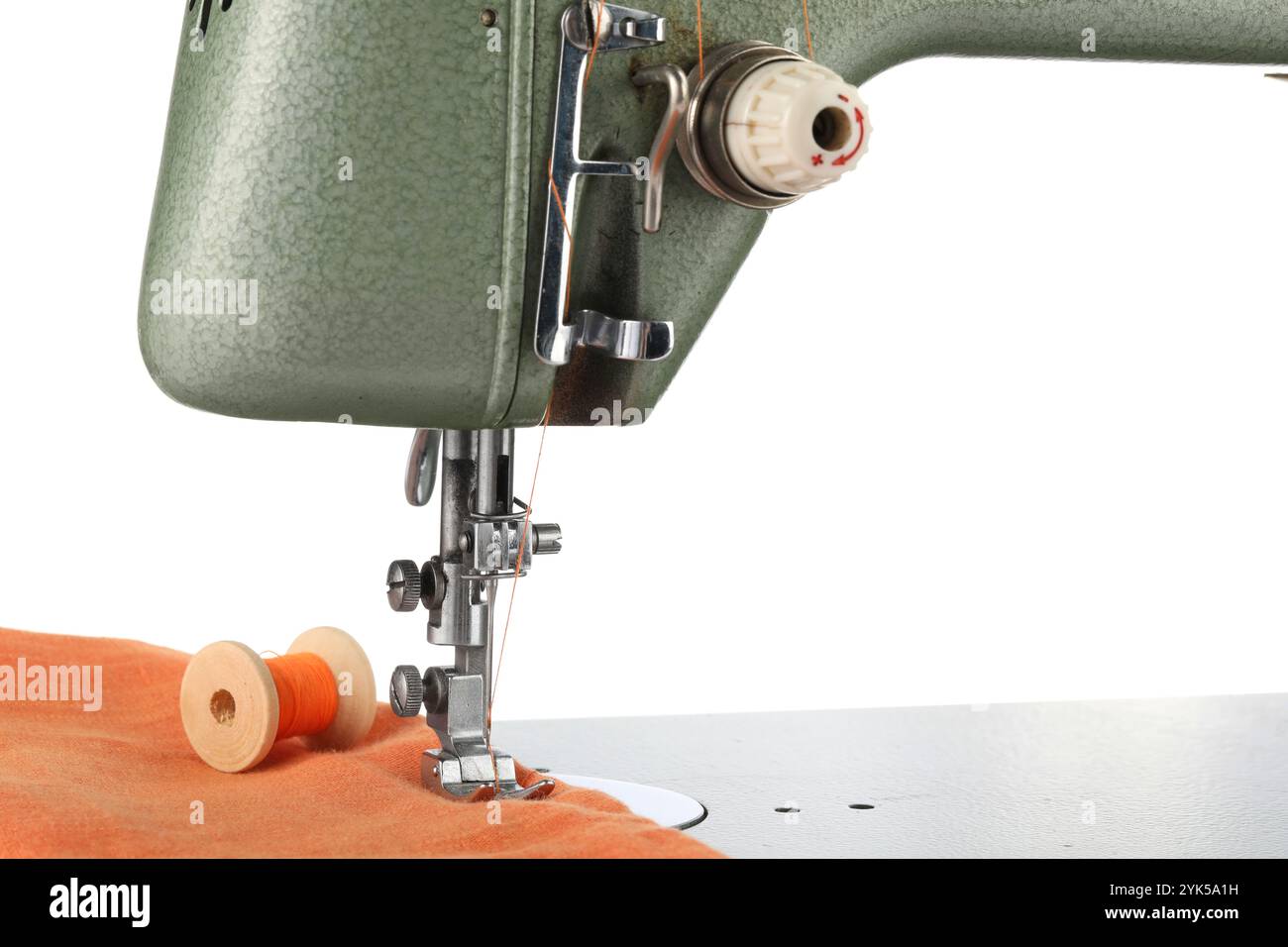 Sewing machine with orange fabric and spool of thread isolated on white ...