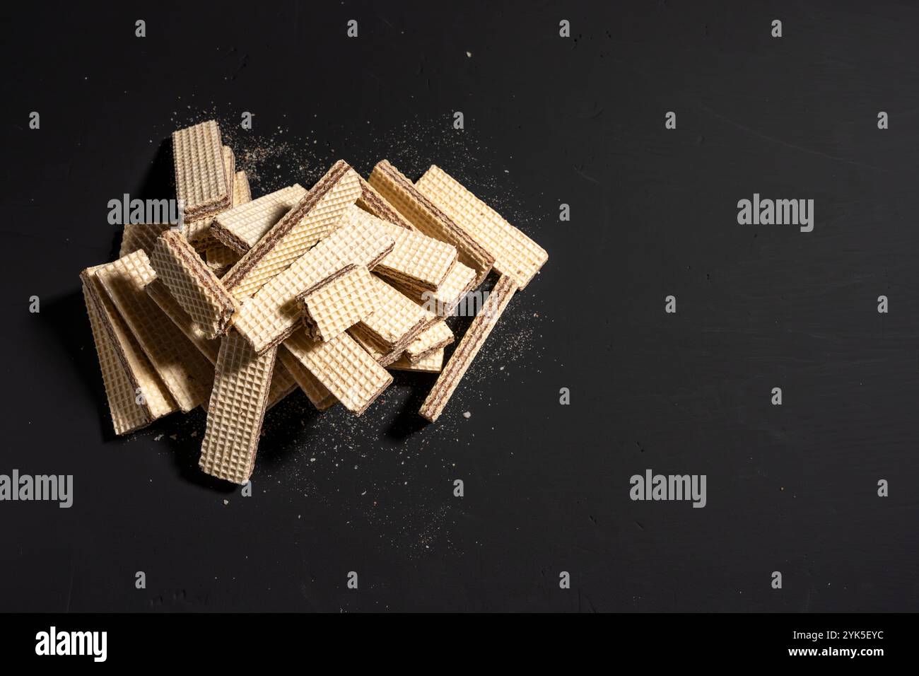 A pile of wafers on a black background. The wafers are in different ...