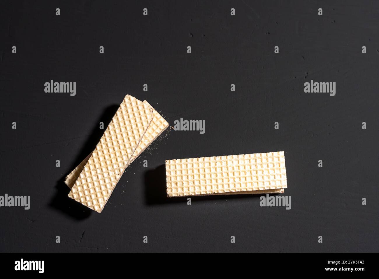 A close up of a few pieces of wafers on a black background. The wafers ...
