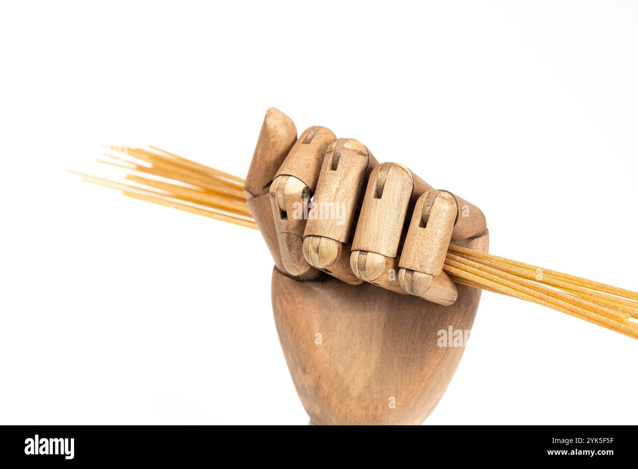whole wheat spaghetti in a wooden hand on a white background Stock ...