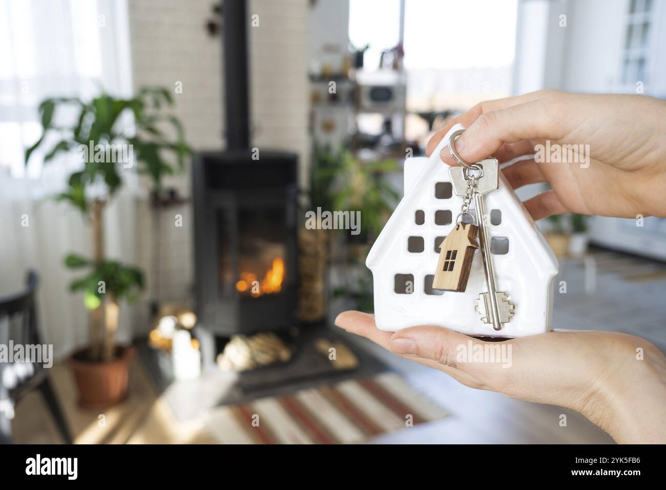 Key to house with keychain against background of fireplace stove with ...